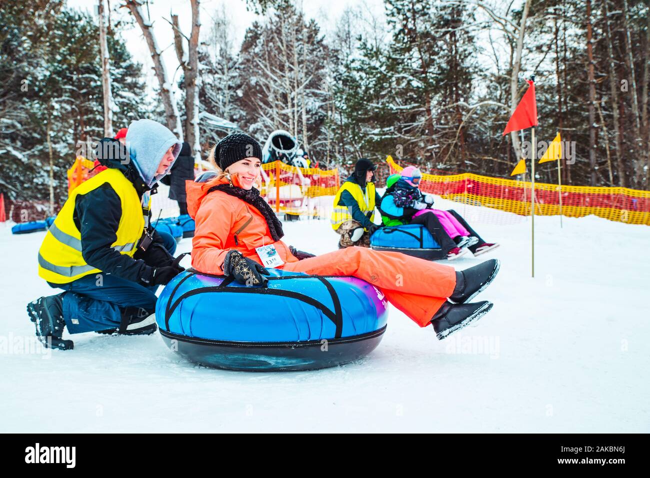 LVIV, UKRAINE - January 7, 2019: family ride down by snowing hill with ...