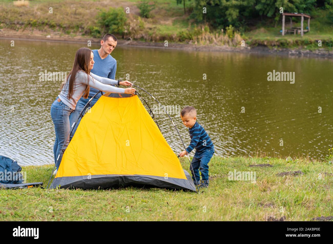 Happy family with little son set up camping tent. Happy childhood ...