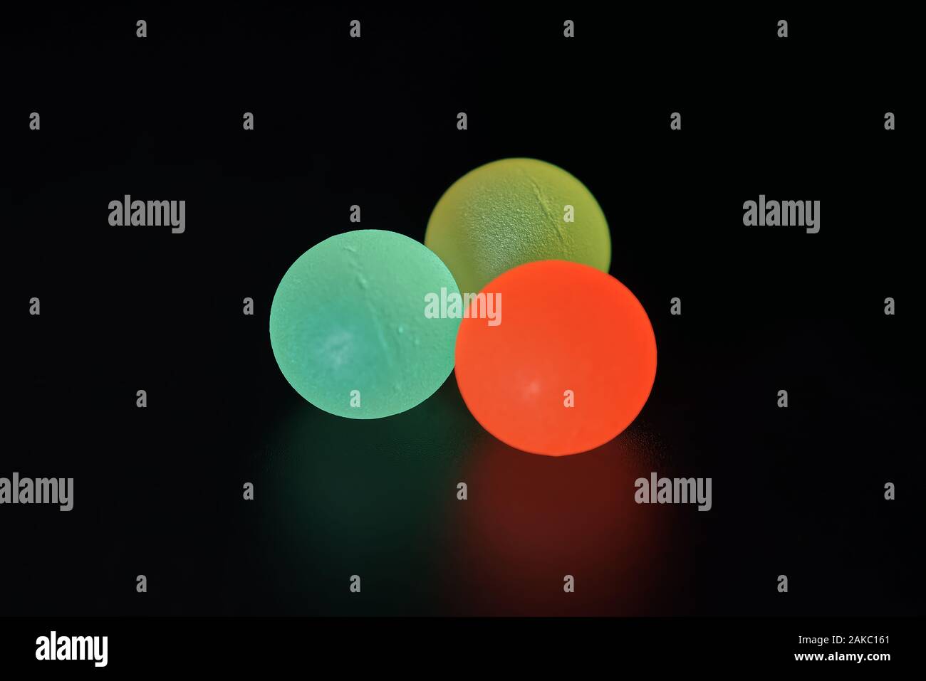 Three rubber balls on black background Stock Photo - Alamy