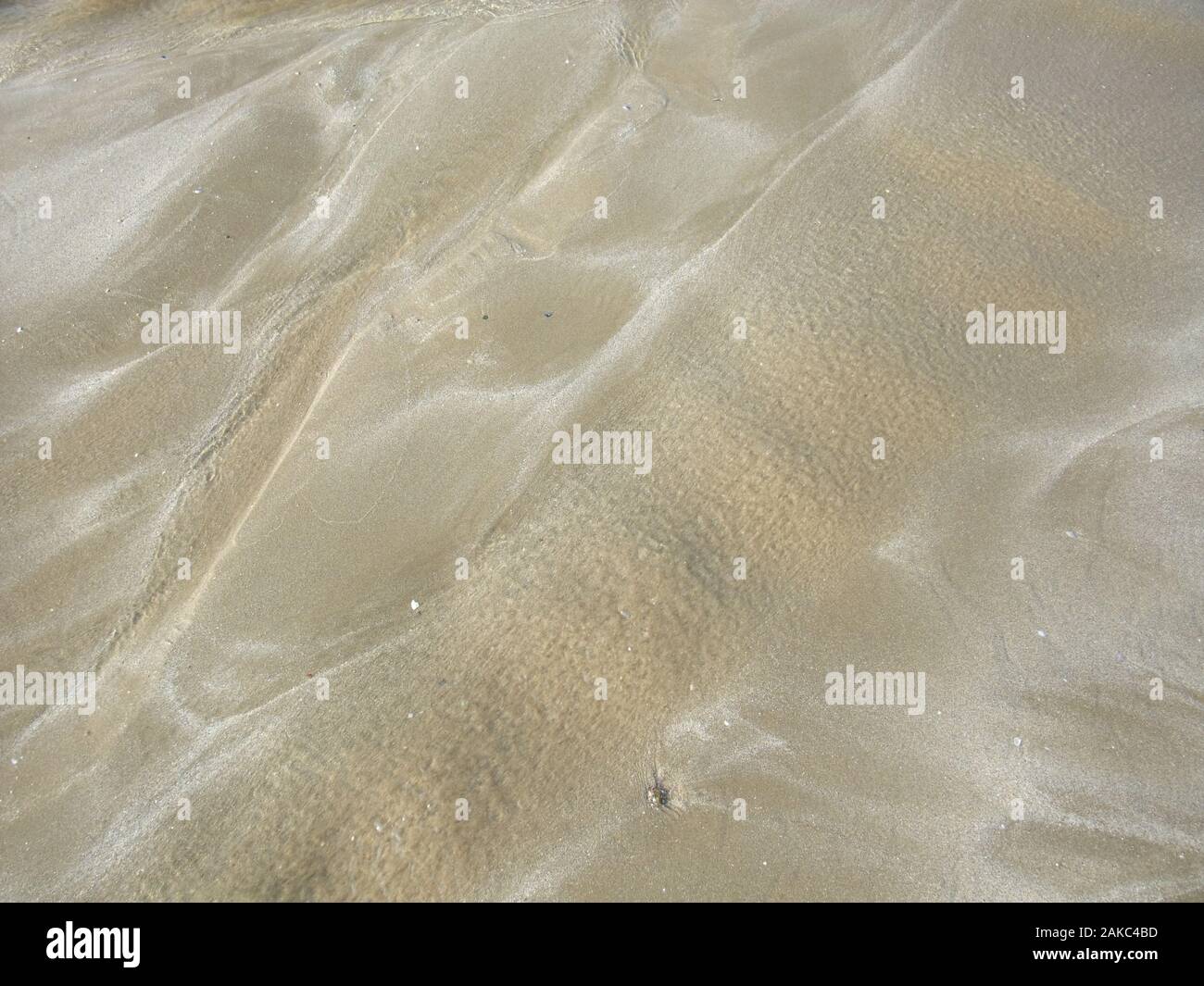 Water flowing over sand forming pattern Stock Photo - Alamy