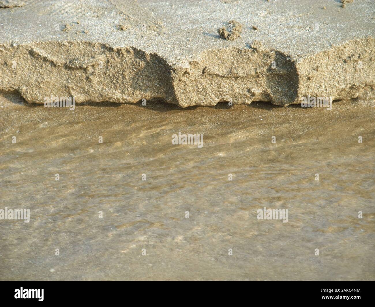 Water flowing over sand forming pattern Stock Photo - Alamy