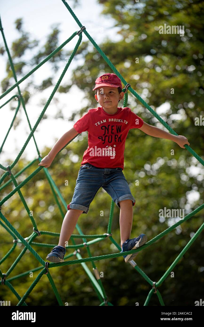 Young boy climbing on a spider web Stock Photo - Alamy