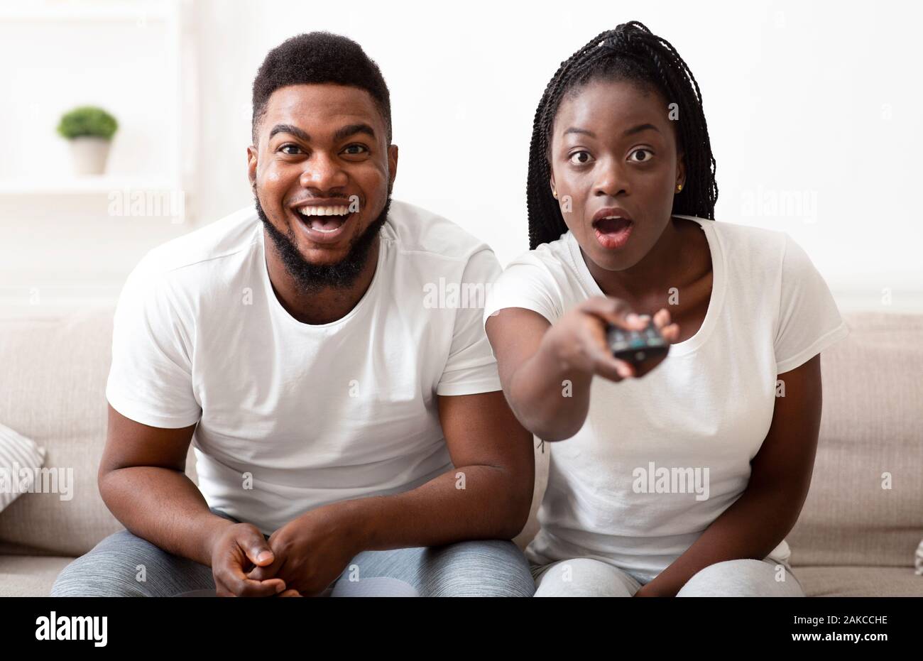 Shocking tv programm. Surprised black couple watching tv with opened ...