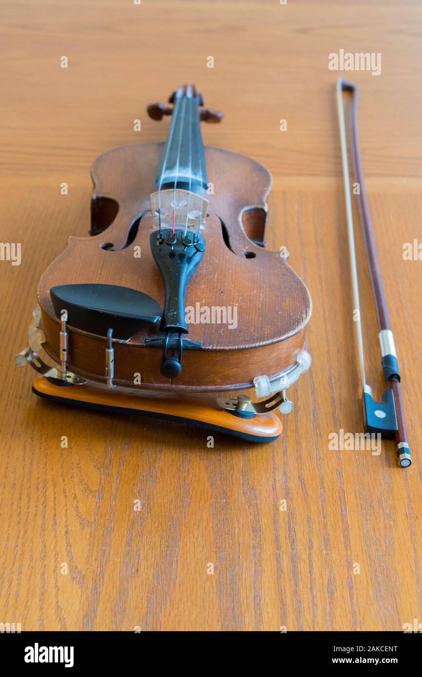 violin lying on a wooden textured table. Violin body and bow on wood ...