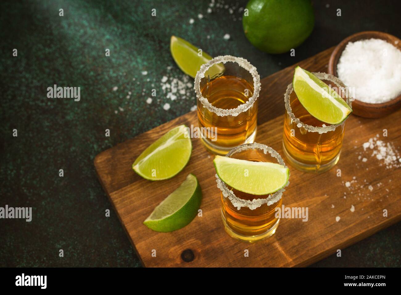 Mexican Gold Tequila shot with lime and salt on dark stone background ...