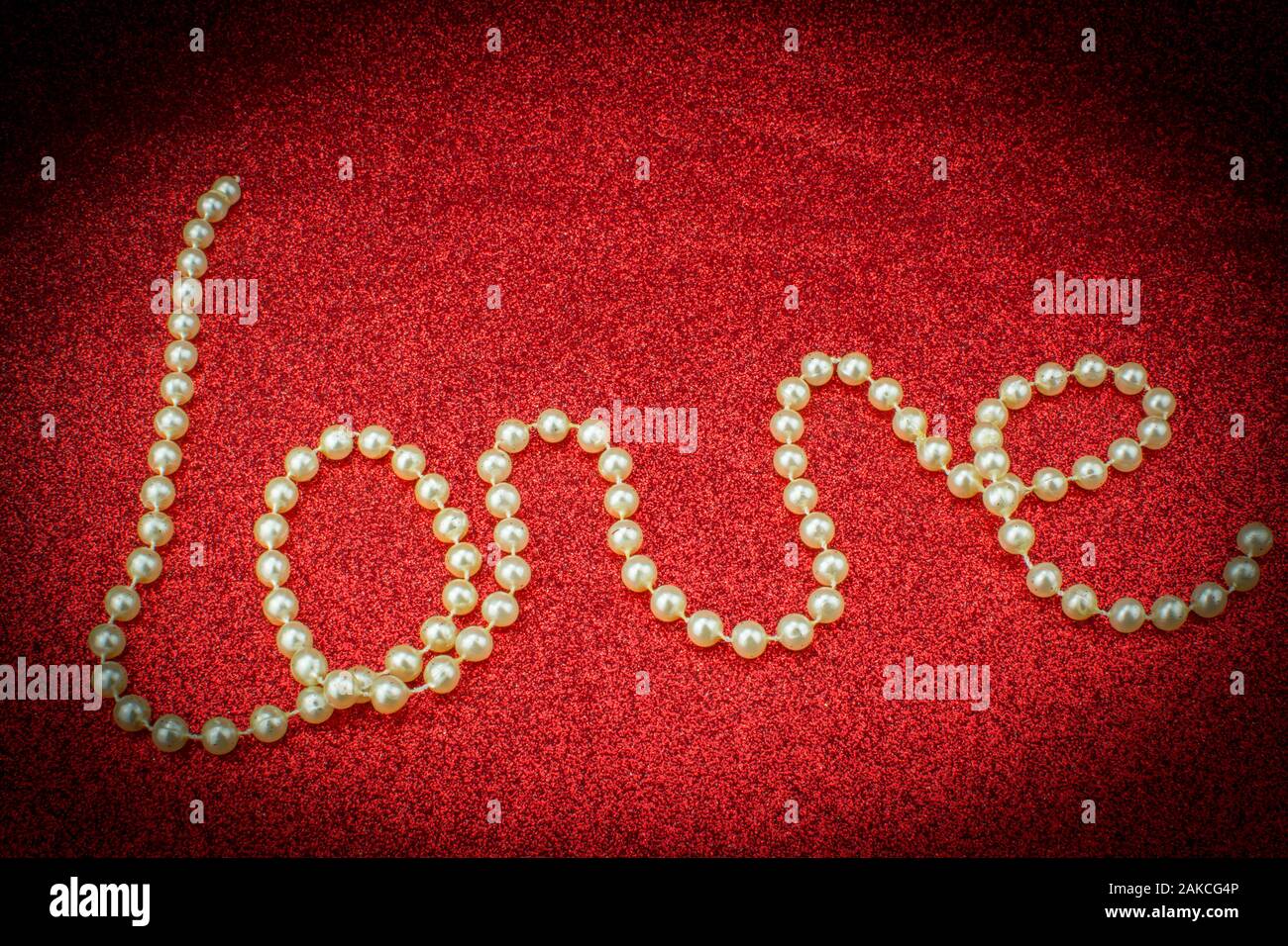 string of pearl on red sparkly background Stock Photo - Alamy