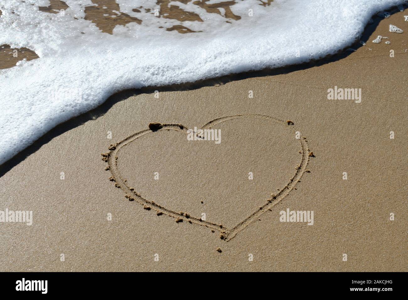 Heart shape drawn in sand at the beach Stock Photo - Alamy
