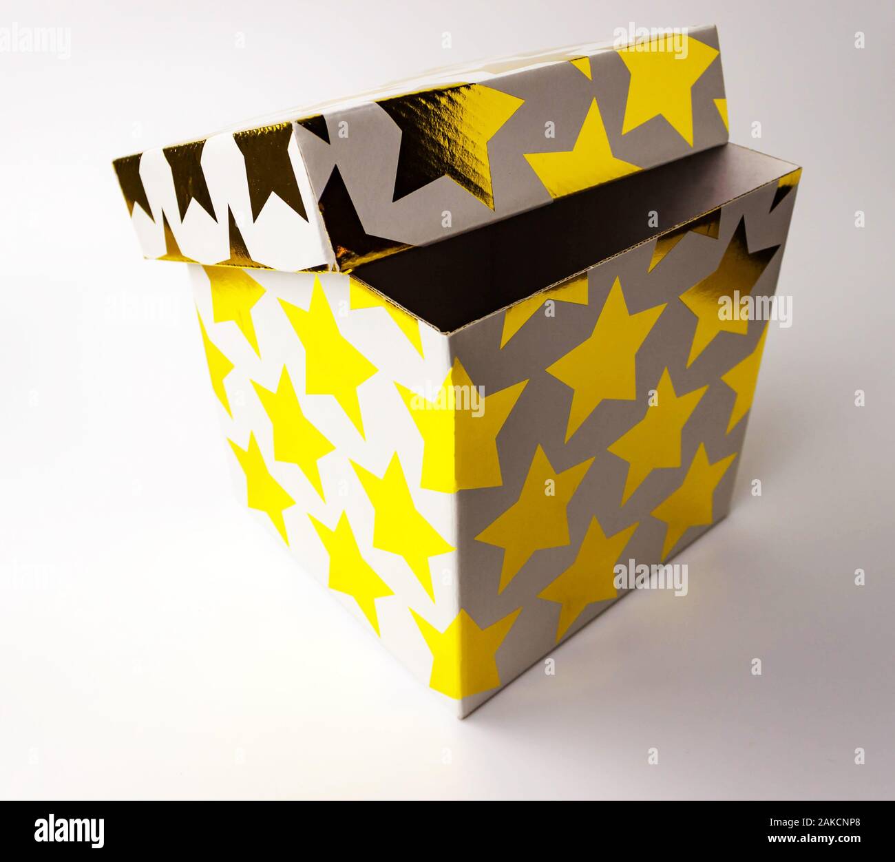 Single white color golden starred gift paper cardboard box on light ...