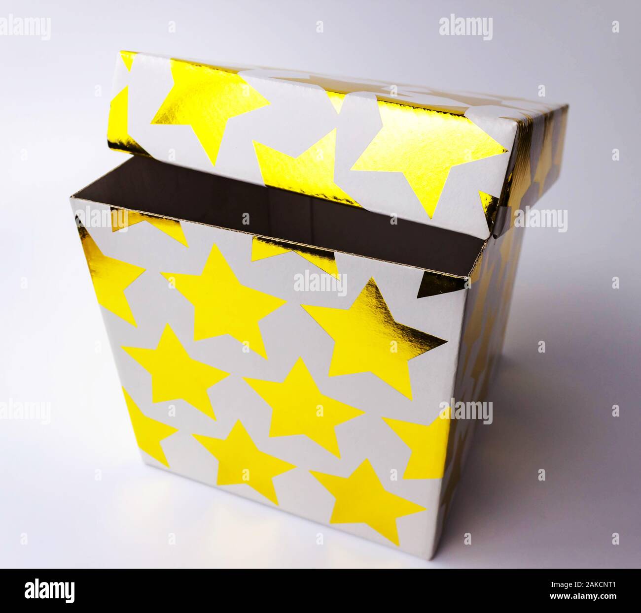 Single white color golden starred gift paper cardboard box on light ...