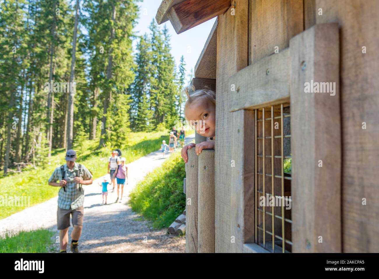 Cute blonde girl playing in wooden house looking through window Stock ...