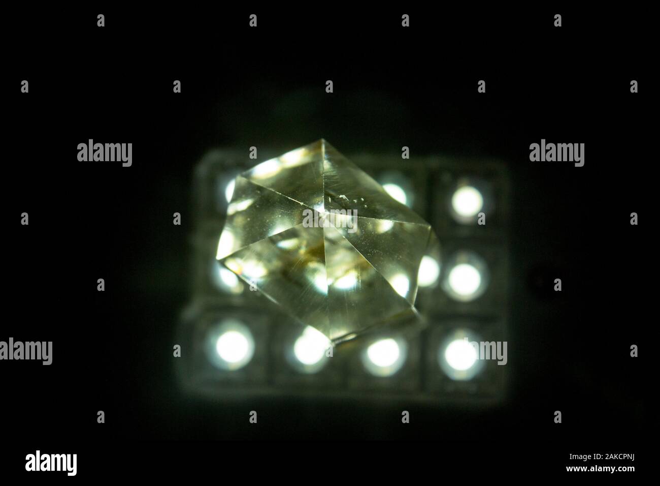 Close up of a pale yellow citrine crystal illuminated from bottom in ...