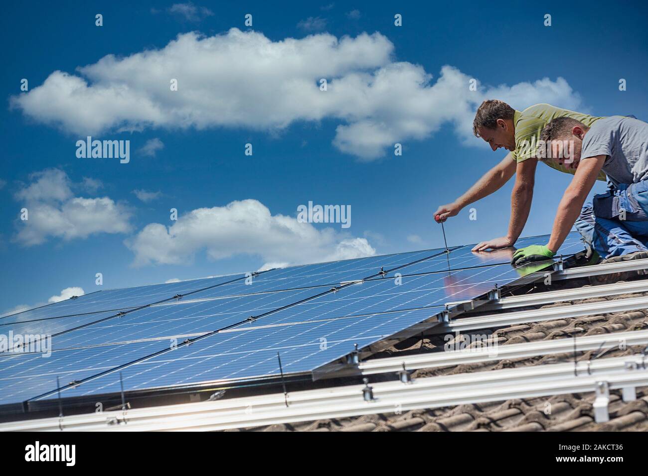 Installing solar photovoltaic panel system. Solar panel technician installing solar panels on ...