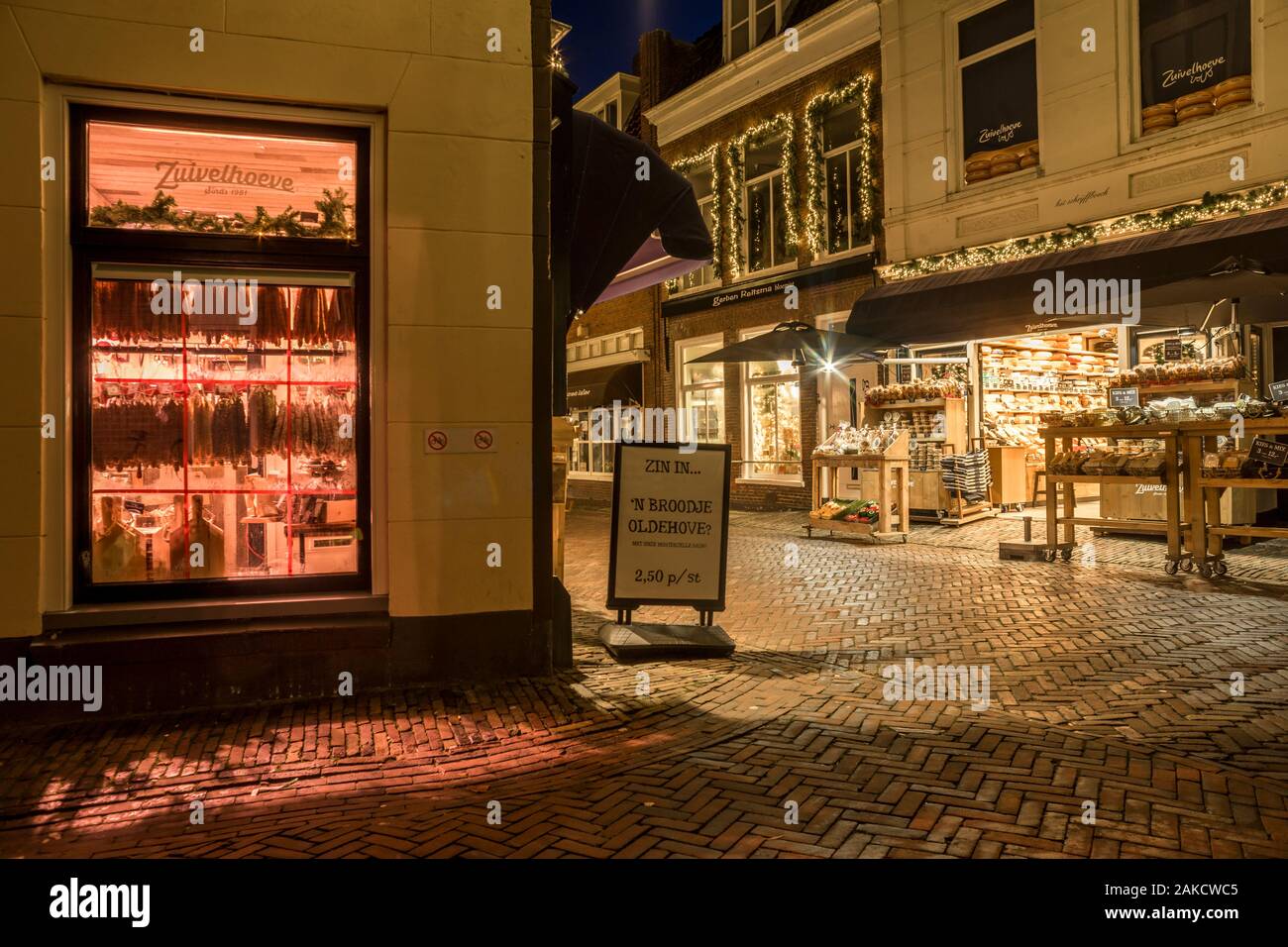 People are shopping in the 'Kleine Kerkstraat' at dusk. The street is ...