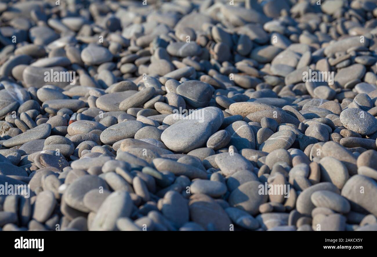 Rounded Pebble beach ground with blurred parts Stock Photo - Alamy