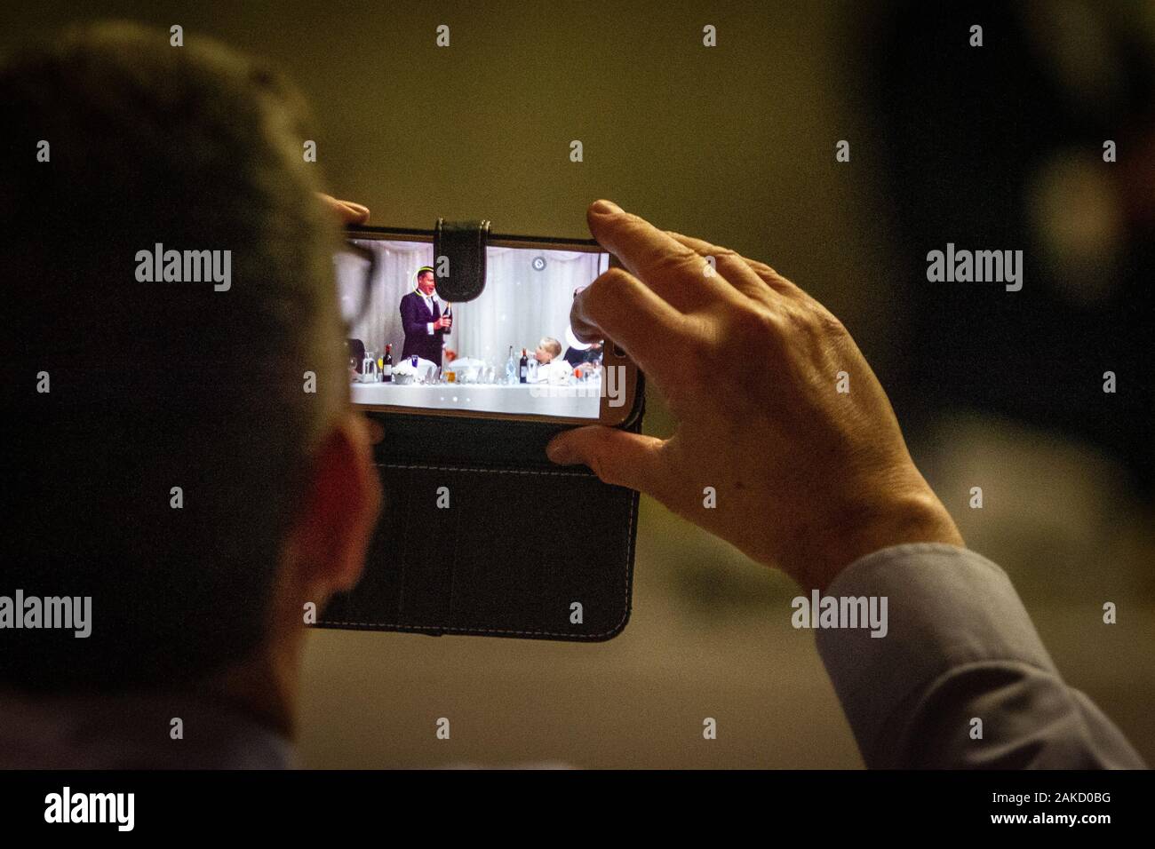wedding guest takes photograph of bride and groom with mobile phone ...