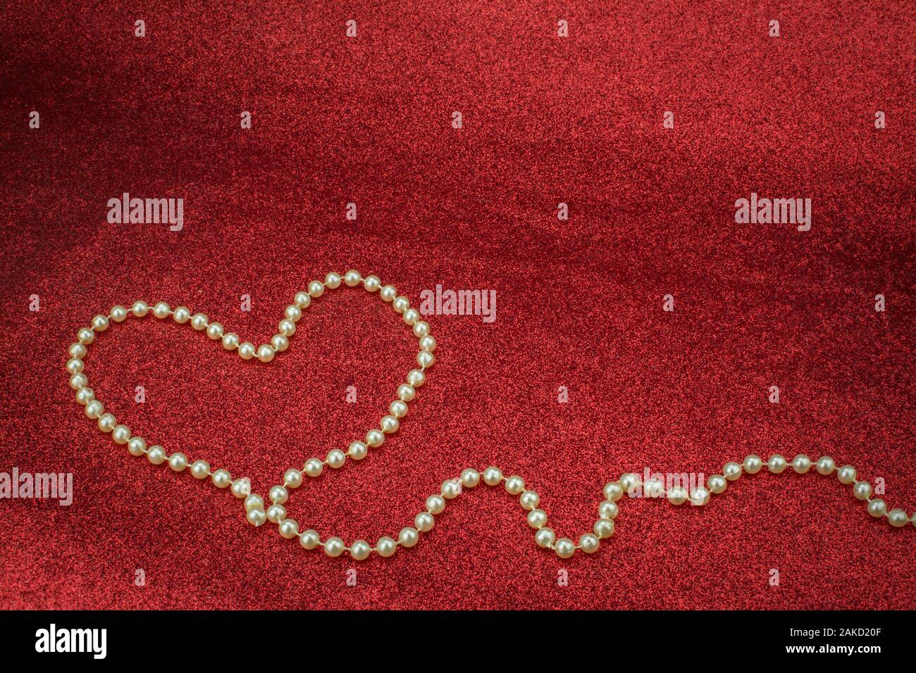 string of pearl on red sparkly background Stock Photo - Alamy