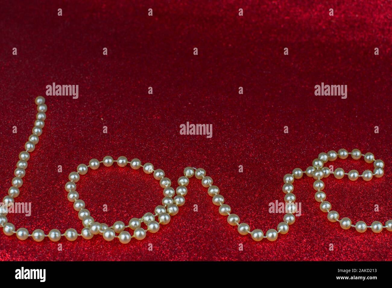 string of pearl on red sparkly background Stock Photo - Alamy