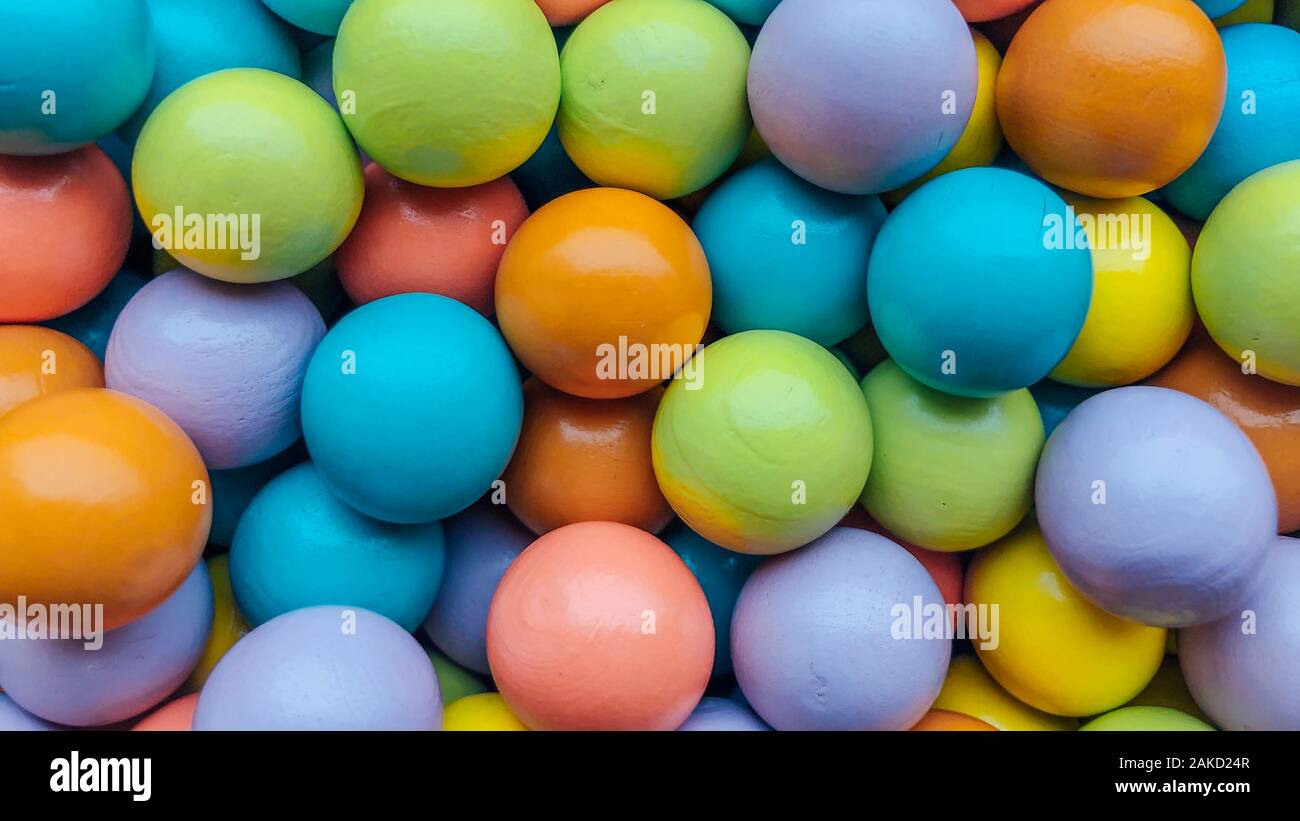 Bright multi-colored background from small wooden colored balls ...
