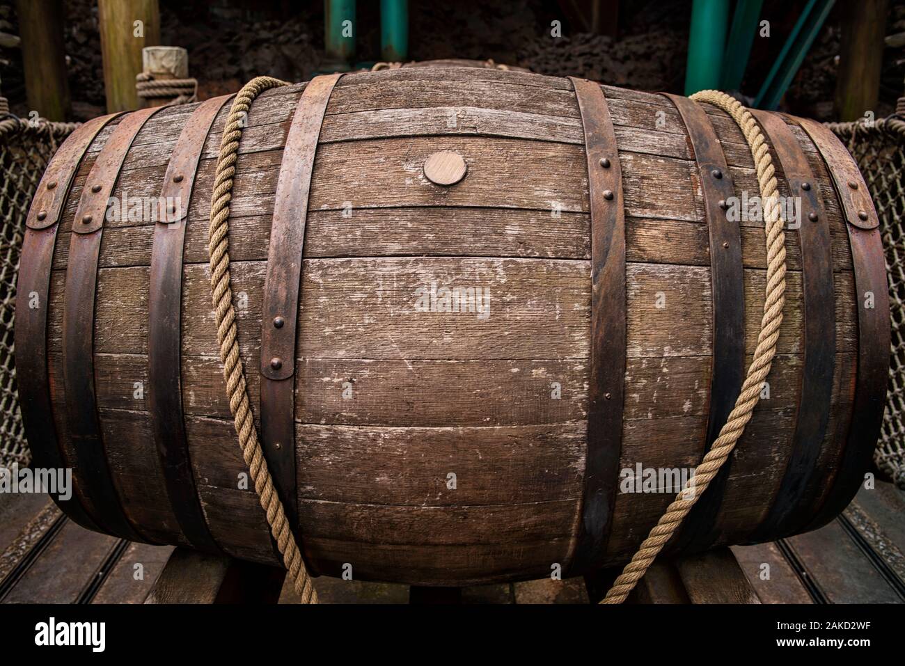 Old large wine wooden barrels on a wooden floor tied with a large rope ...