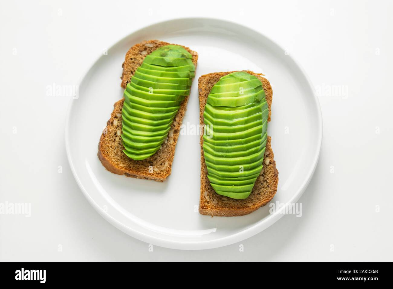 Avocado slices on white background. Avocado toast in white round plate ...
