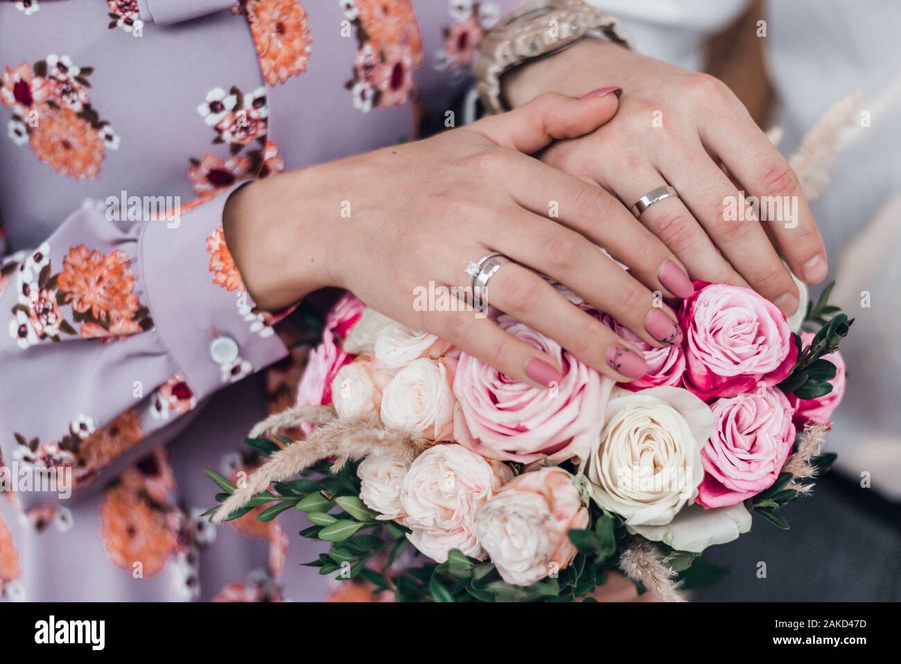 A romantic couple holding hands with wedding rings Stock Photo - Alamy