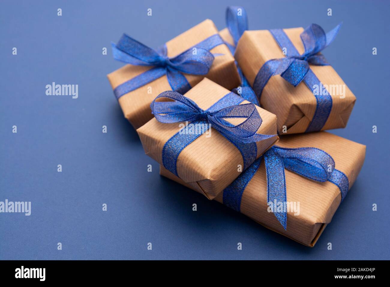 Christmas or birthday presents. Craft paper wrapped gift boxes on blue ...