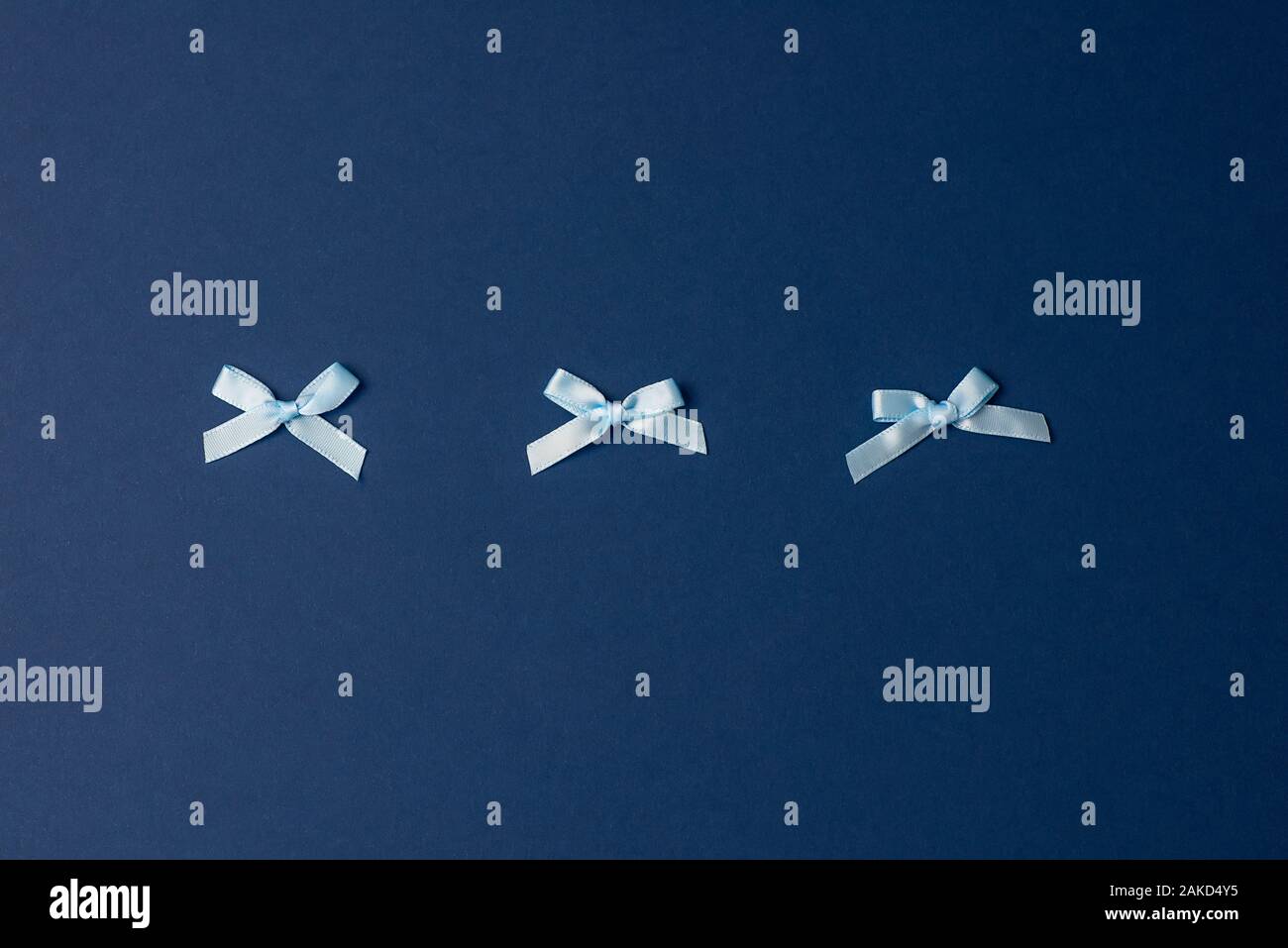 Three blue bows on a blue classic background Stock Photo - Alamy