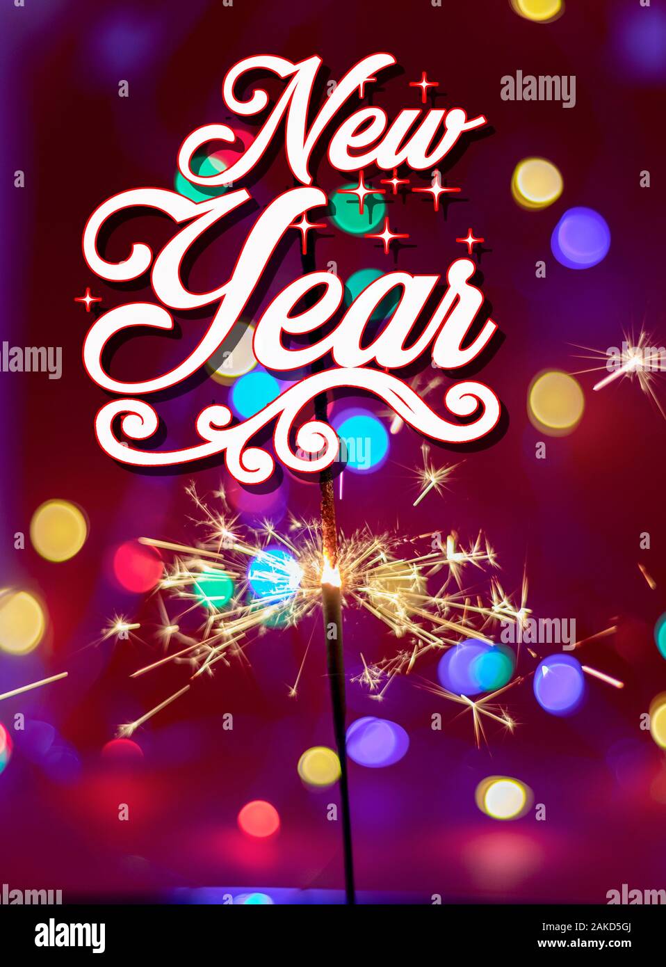 Happy new year.Glittering burning sparkler on red and color bukeh ...