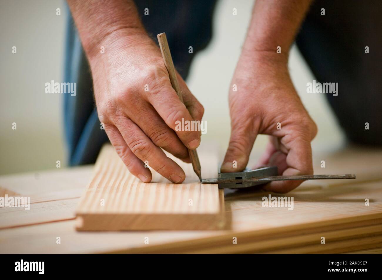 Hands of a male builder measuring a door and marking it with a pencil ...