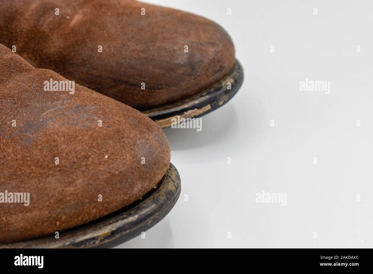 close up of the toes of a pair of brown mens leather boots isolated on ...