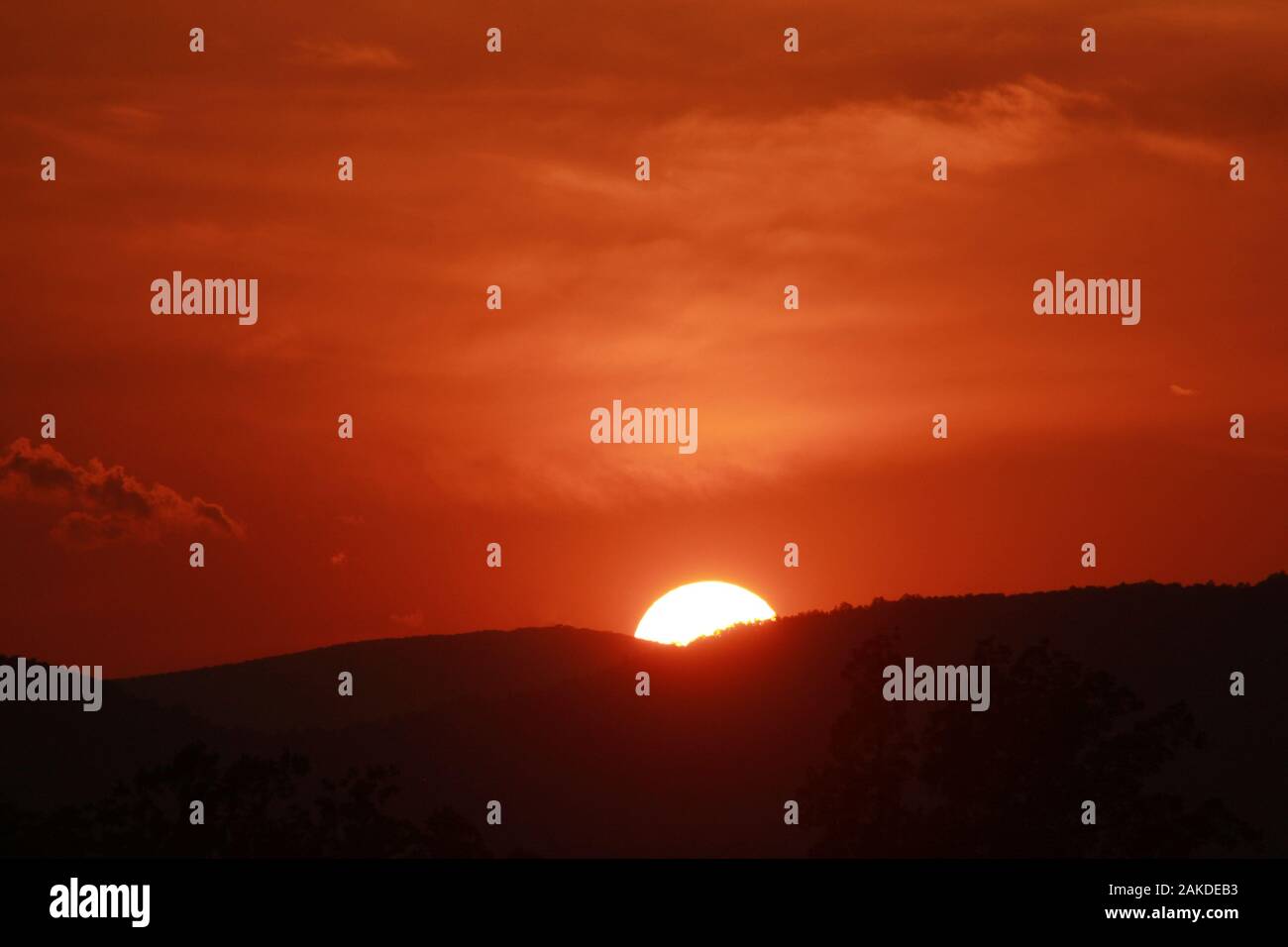 Sun disappearing behind the hills at night Stock Photo - Alamy