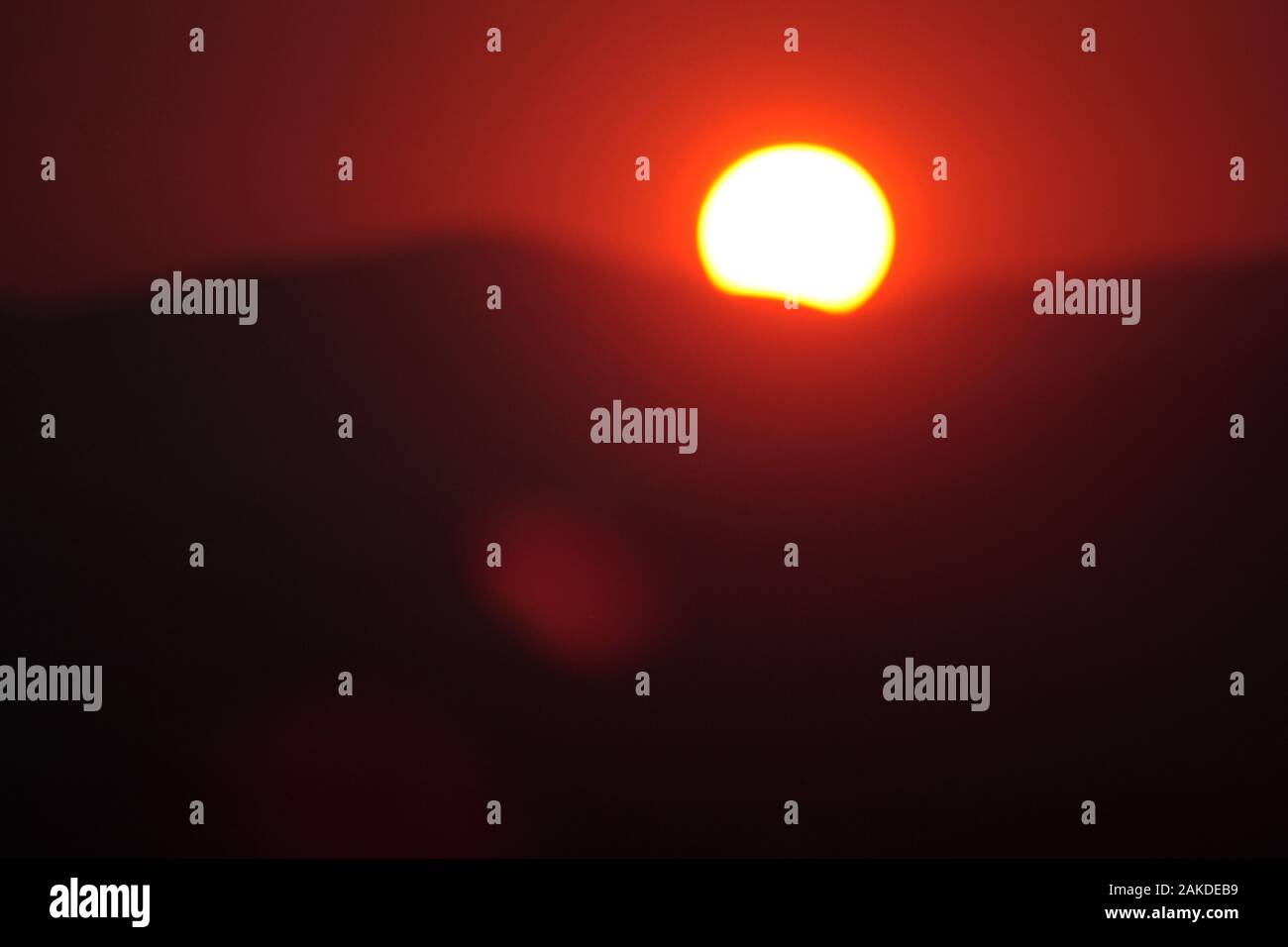 Sun disappearing behind the hills at night Stock Photo - Alamy