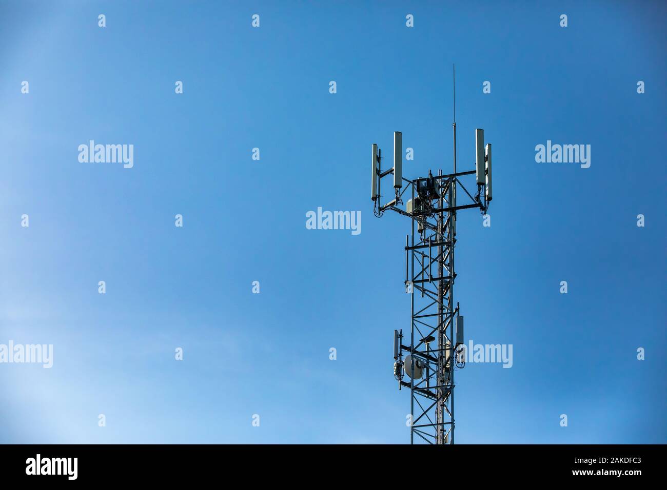 A single cellular base station is seen against a blue sky, cell tower ...