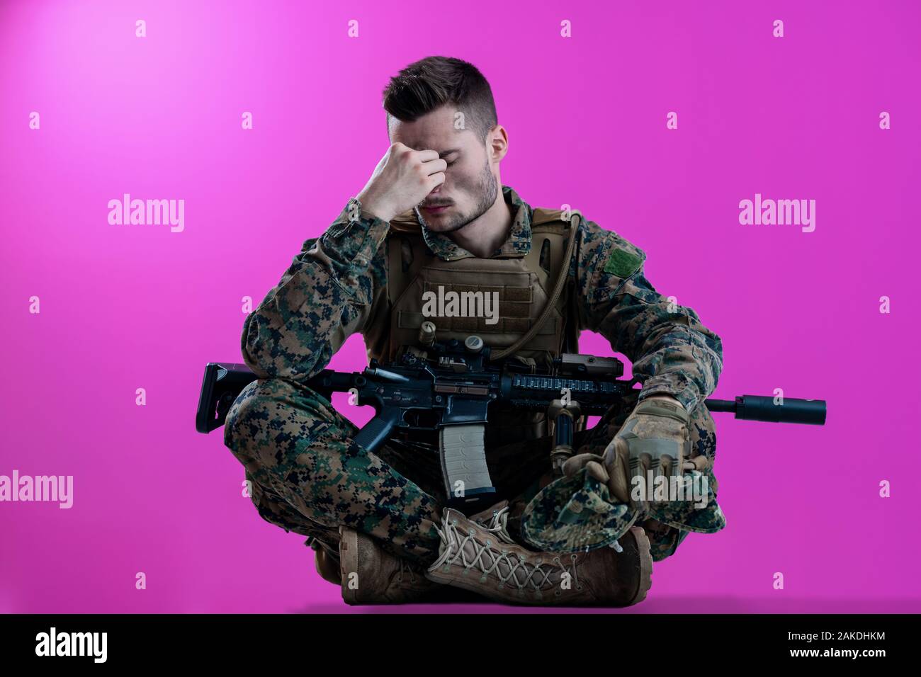 sad soldier has psychological problems holding his head in a squatting ...