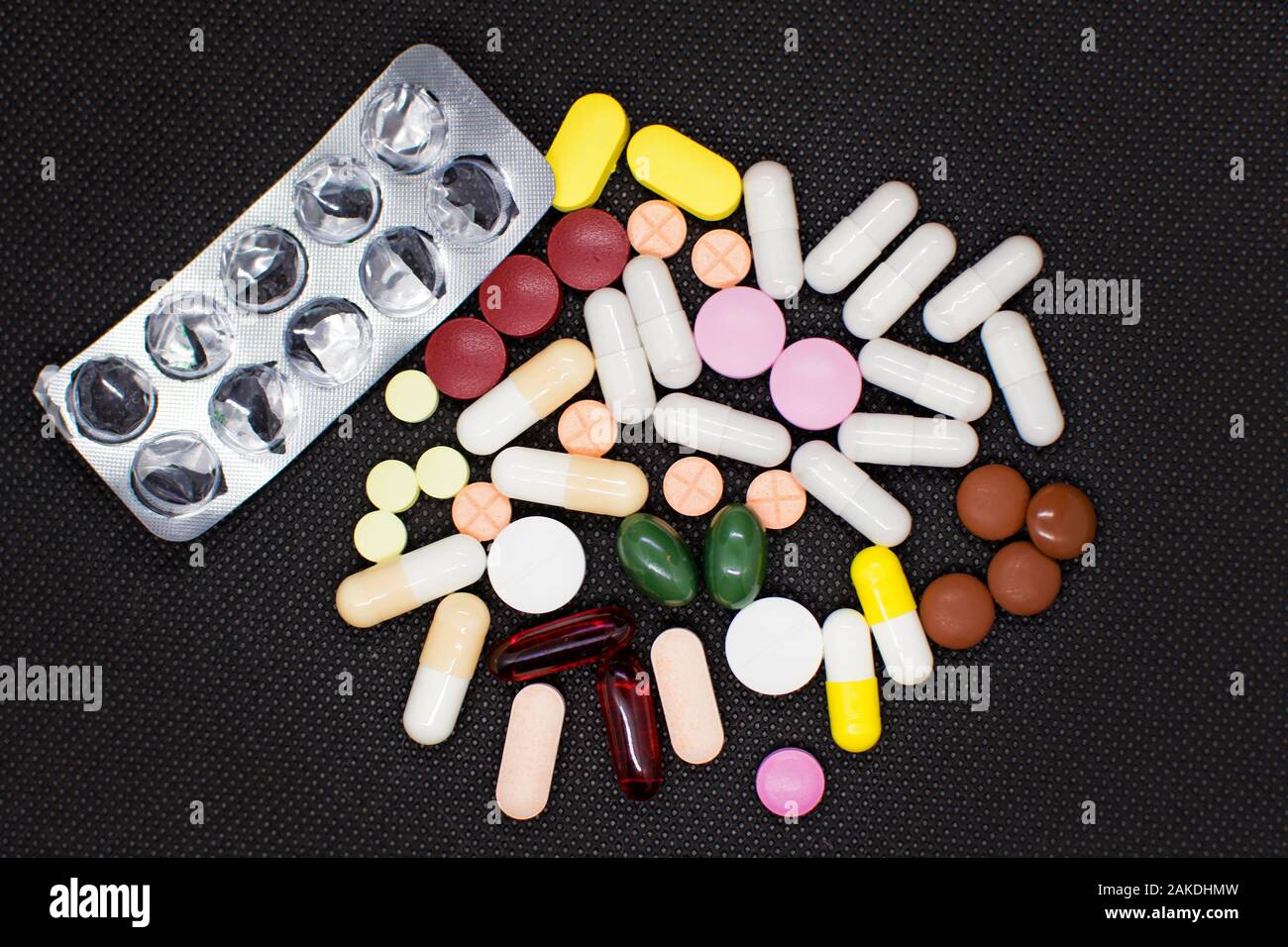 many tablets of different colors and shapes and an empty blister from ...