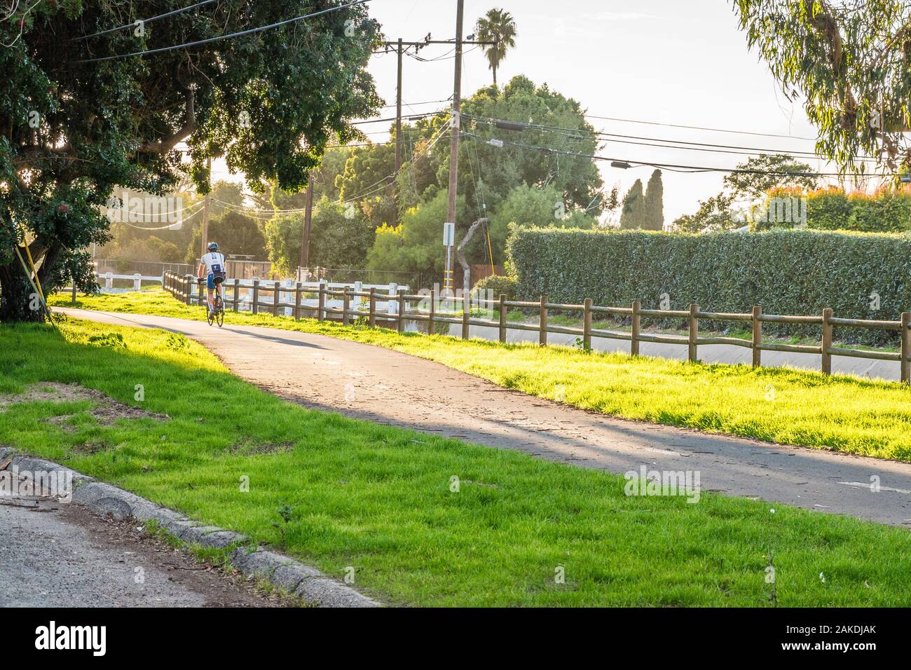 A much used bike path in late afternoon dramatic light with a male bike ...