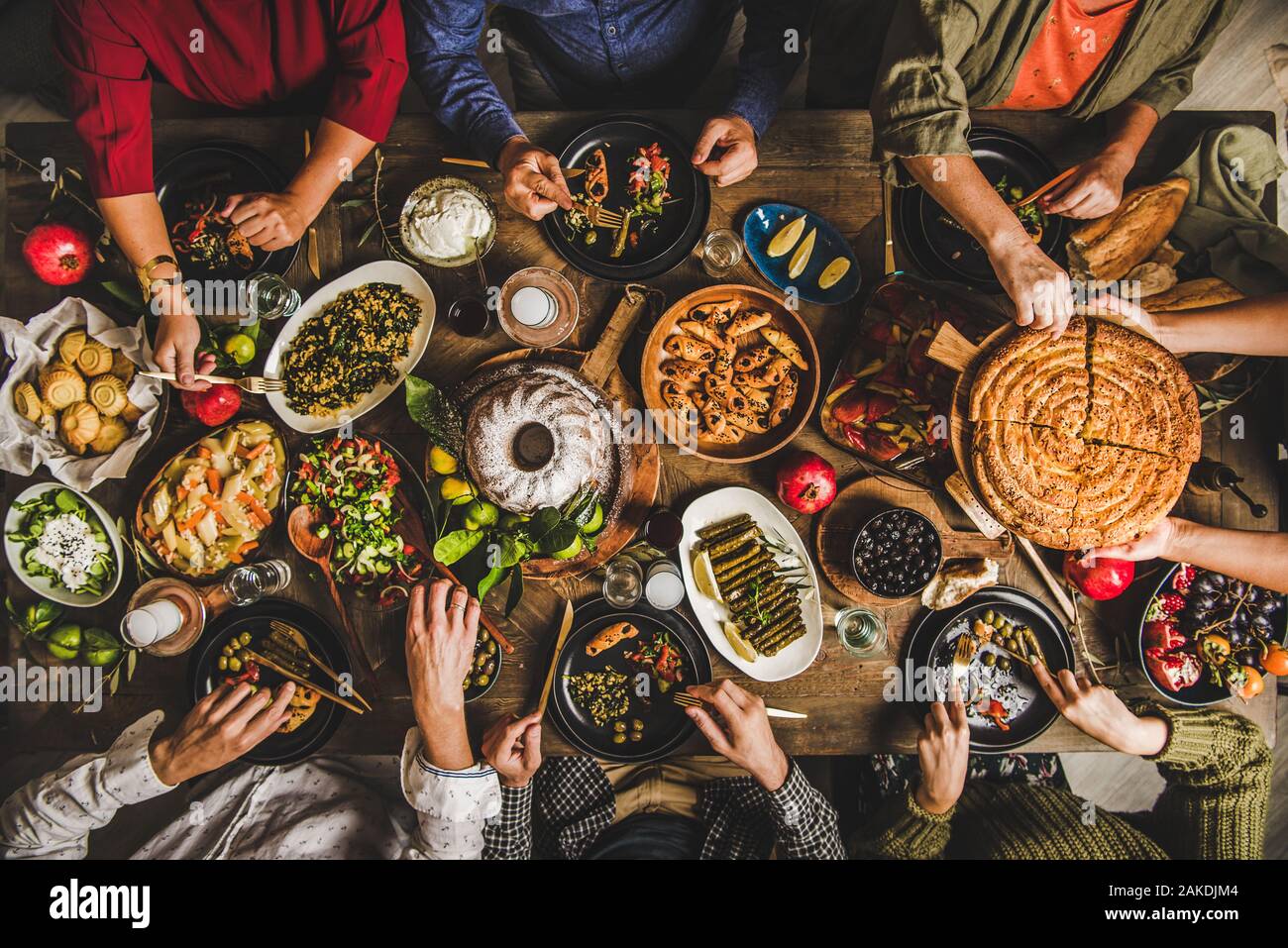 Turkish family celebrating at table with traditional foods and raki ...