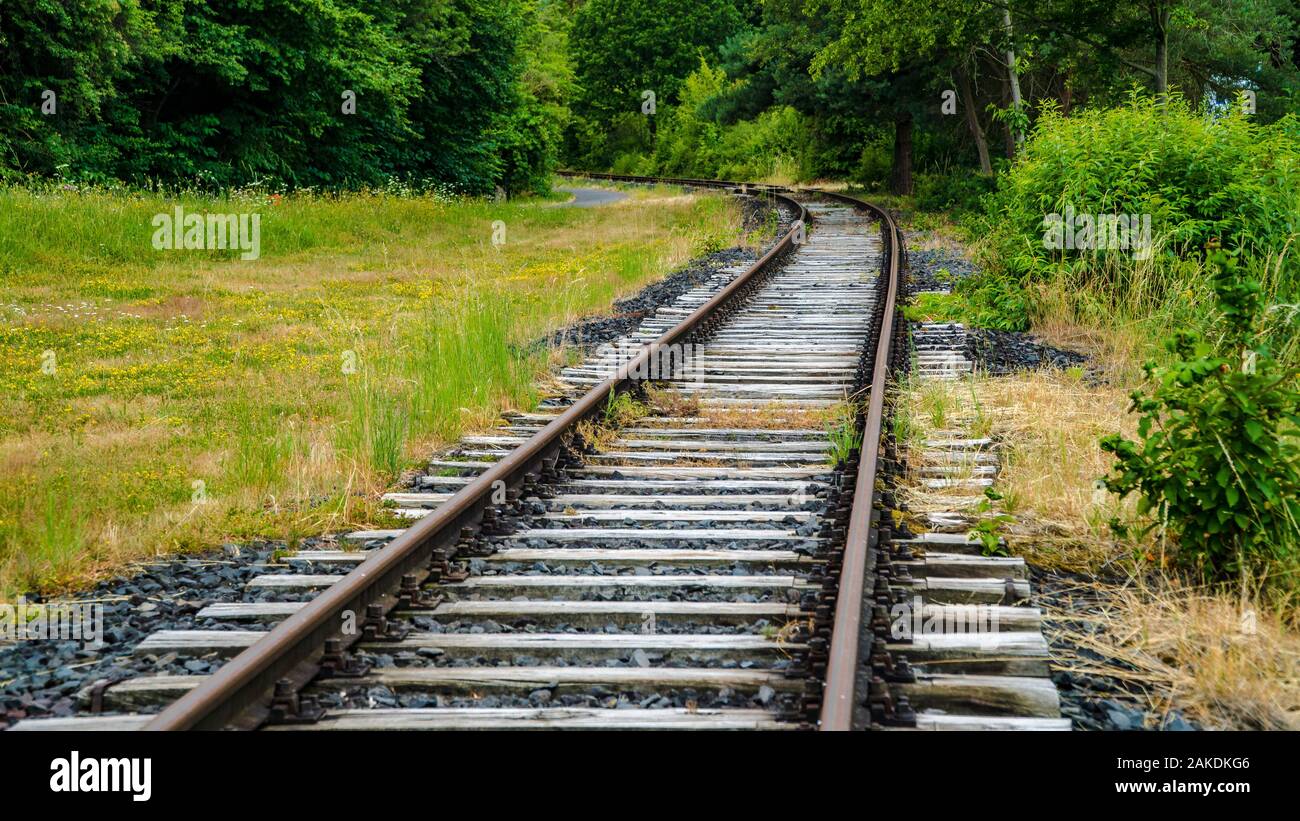 An old train track that crosses a field of grass Stock Photo - Alamy