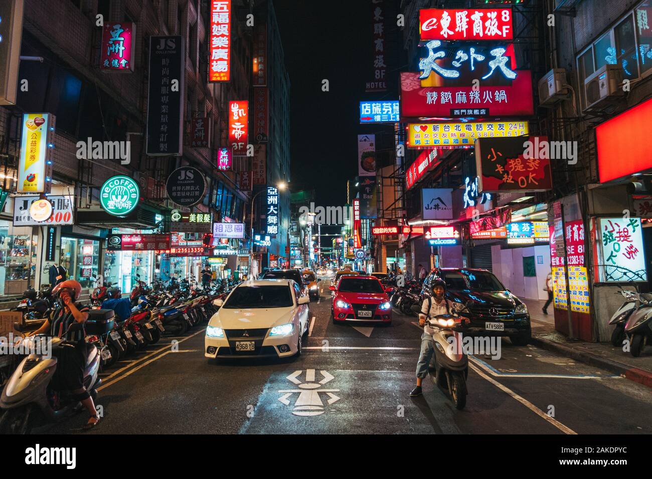 Bright illuminated signs line the streets as traffic trundles by in ...