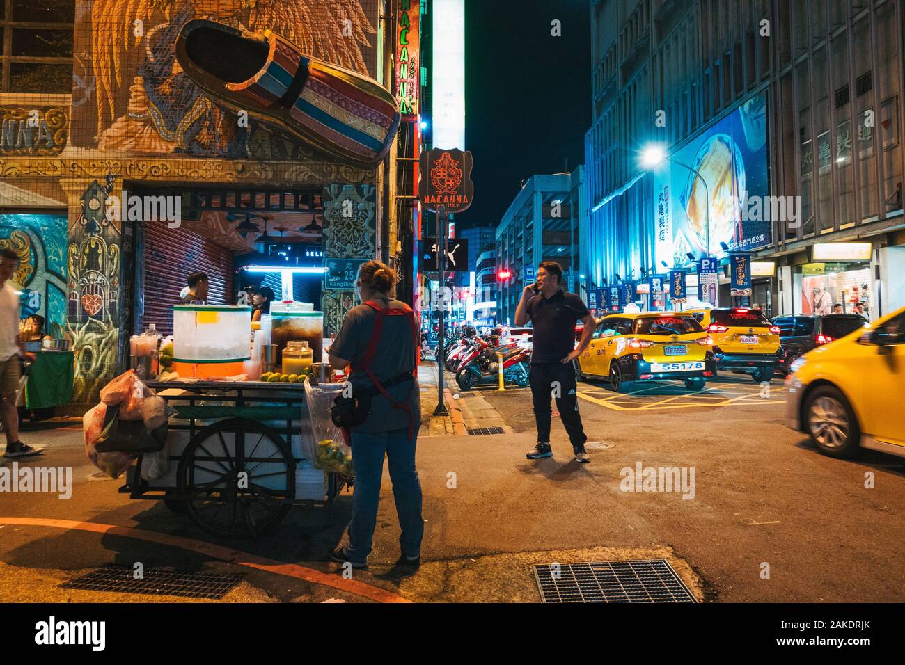A street vendor sells lemonade on a street corner opposite a giant shoe ...