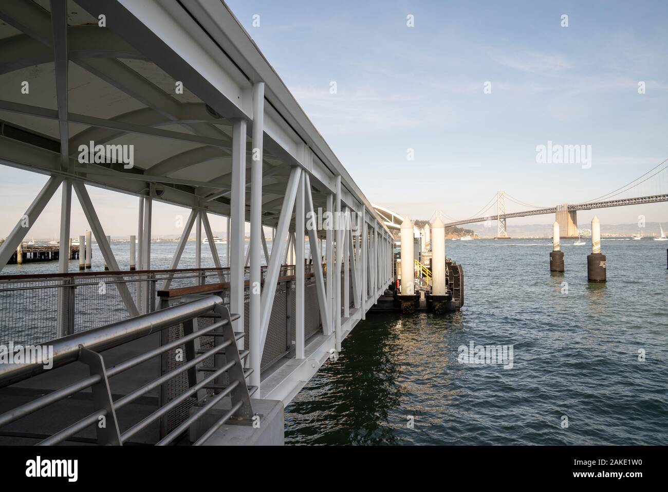 Passenger ferry boarding area in front of bridge in sunny bay area ...
