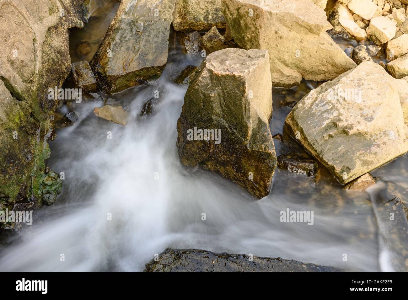 long exposure of water running to a river Stock Photo - Alamy