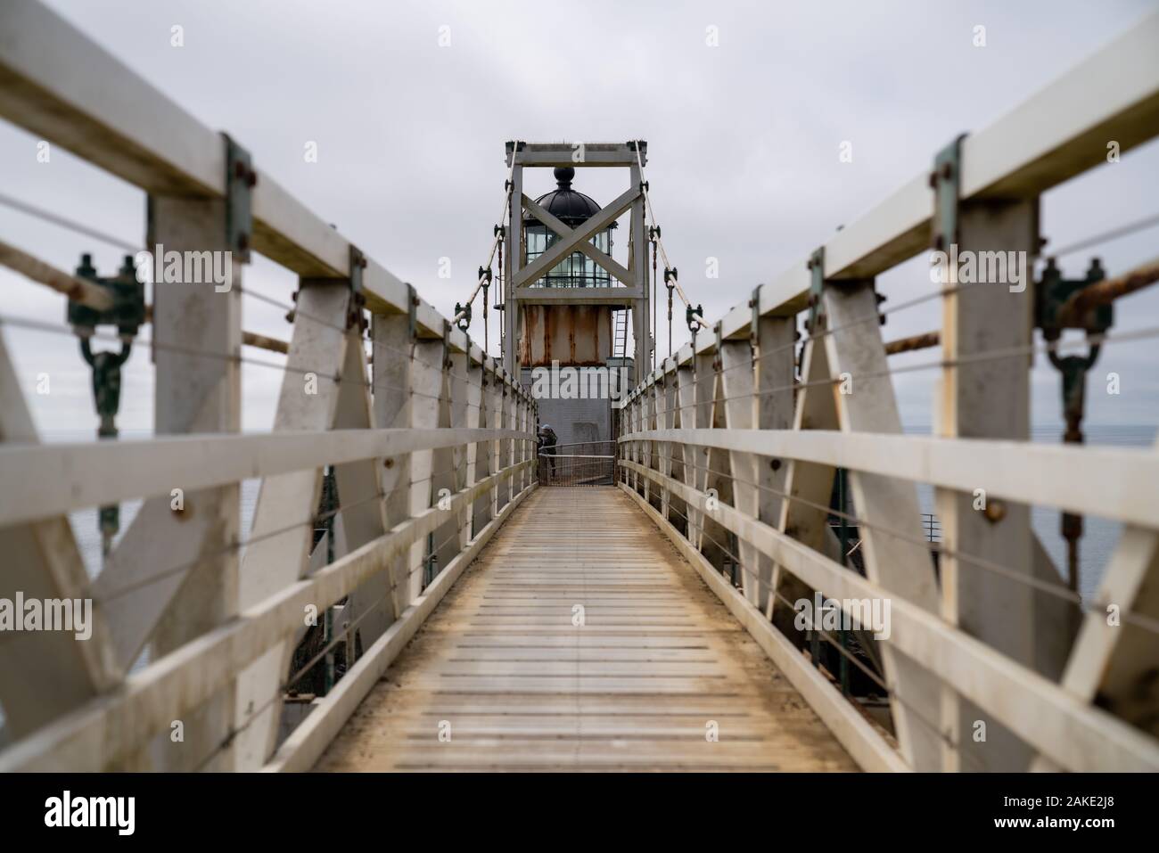 Small white suspension bridge foot path leading to lighthouse Stock ...