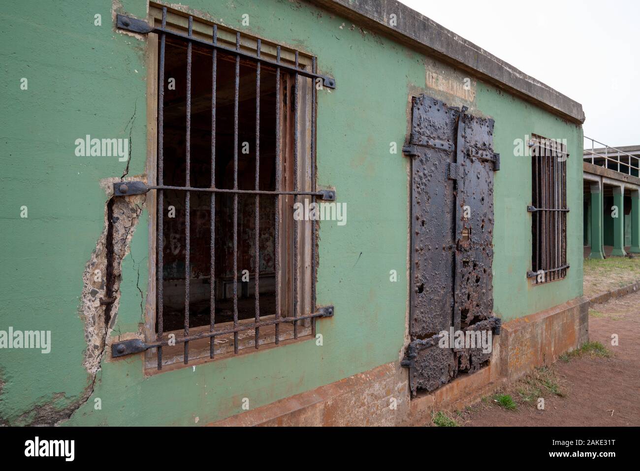 Green broken down building with rusted metal gates and doors Stock ...