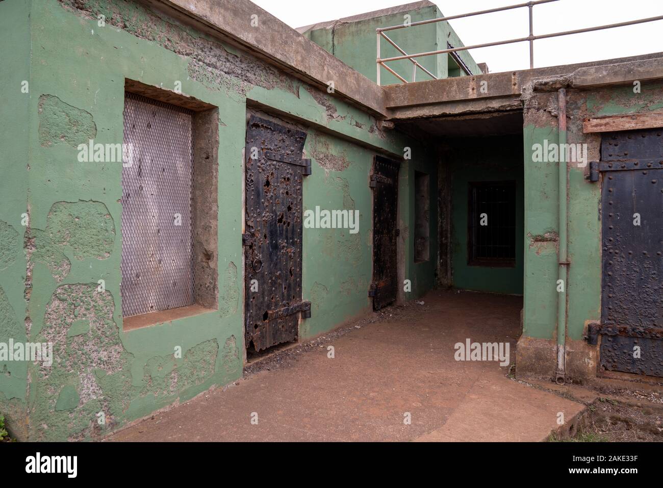 Broken down prison building structure with rusted doors and crumbling ...