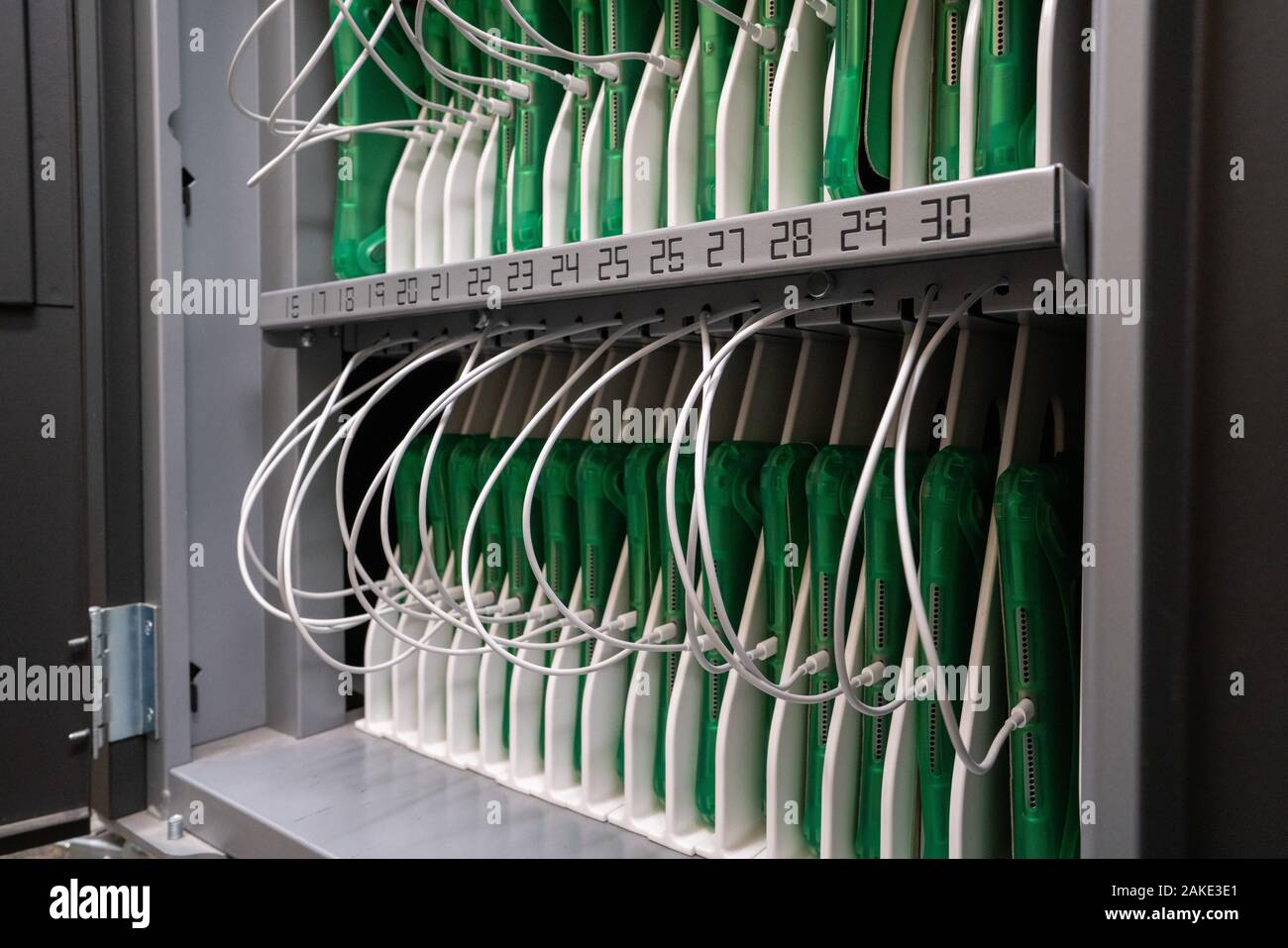 Cabinet of charging tablets neatly organized for use in classroom ...