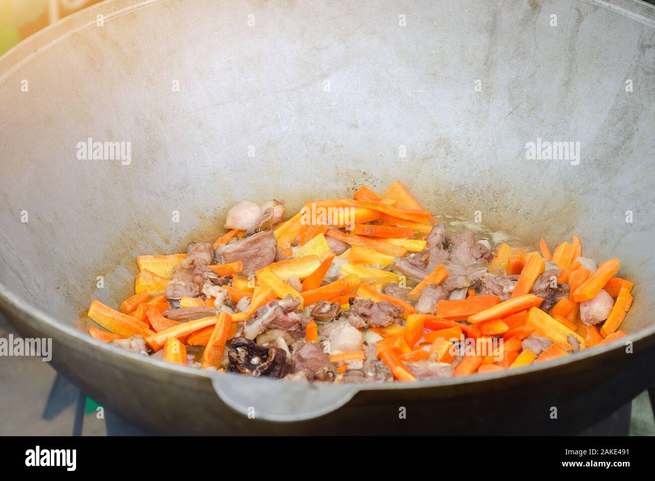 Cooking meat outdoors in cast-iron cauldron Stock Photo - Alamy