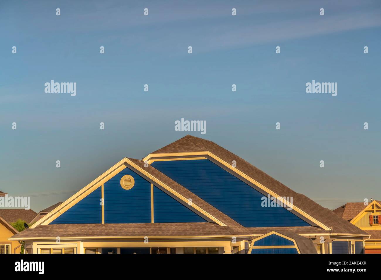Close up of roof structure of home with blue gable wall and round gable ...