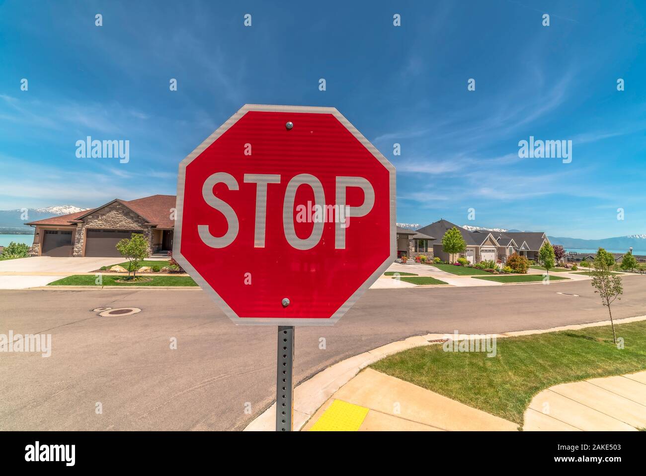 Selective focus of a red and white stop sign against paved road and ...