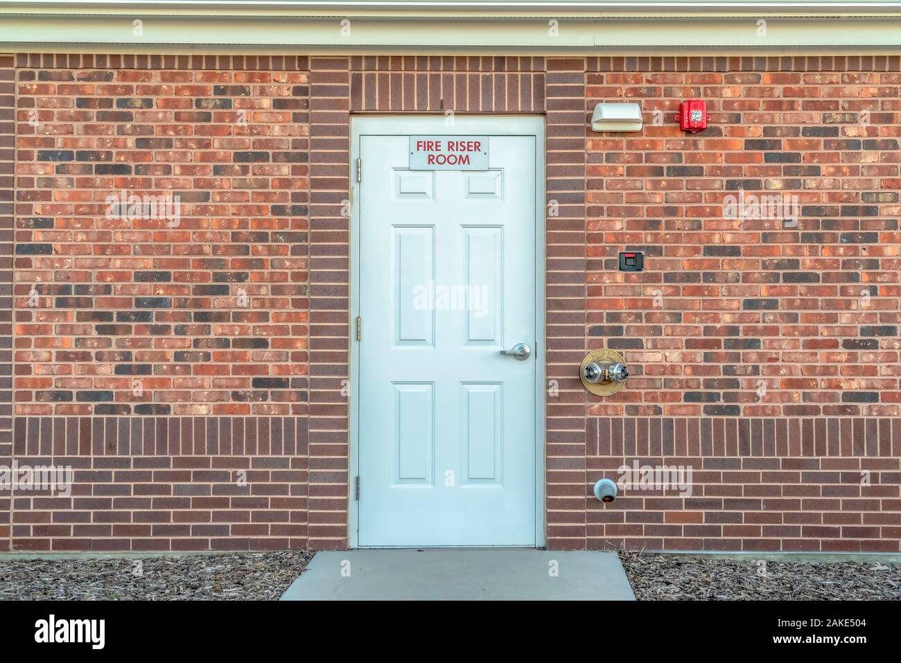 Fire Riser Room sign on the white wood door of a building with red ...